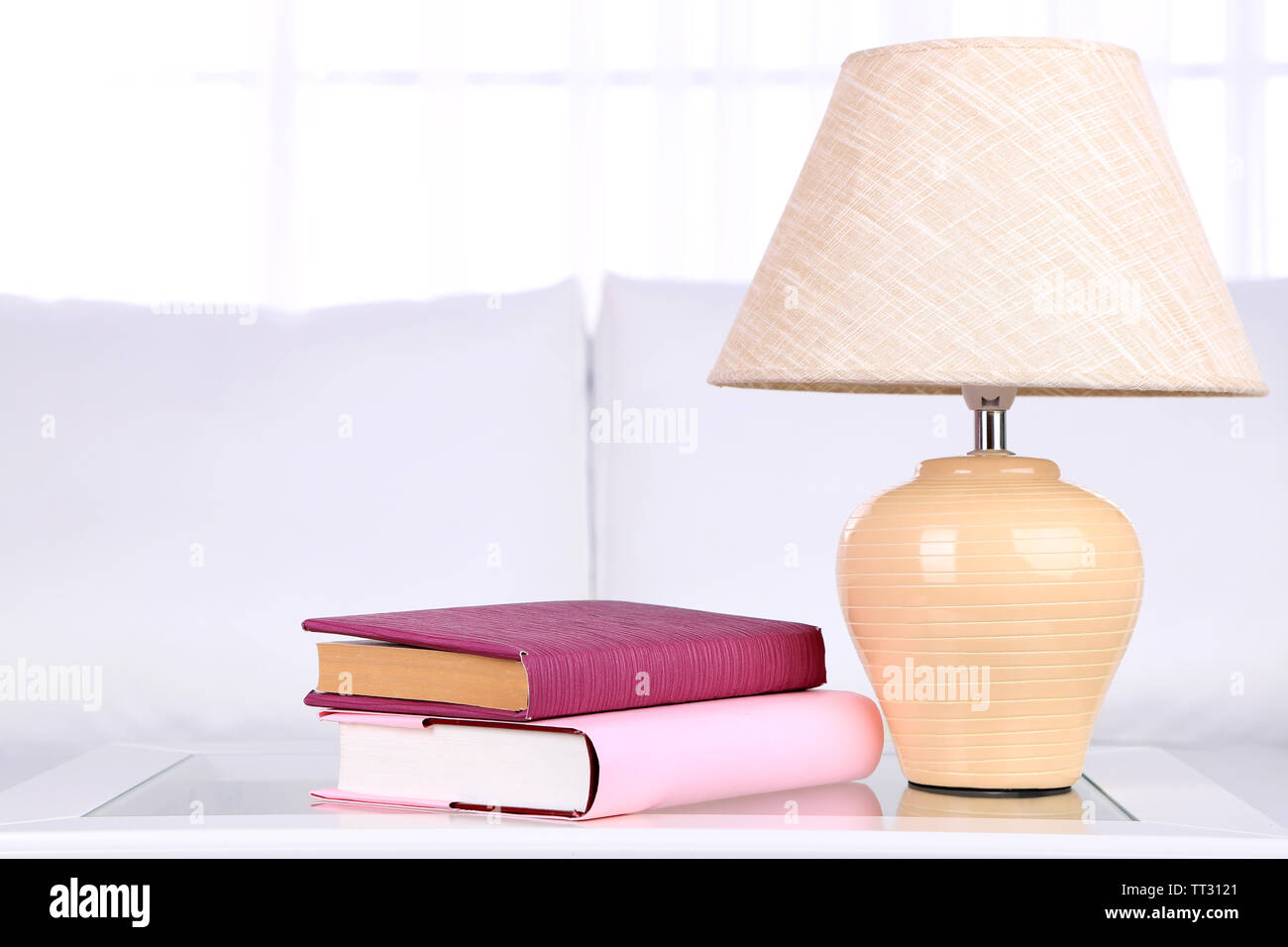 Books and lamp on coffee table in room Stock Photo - Alamy