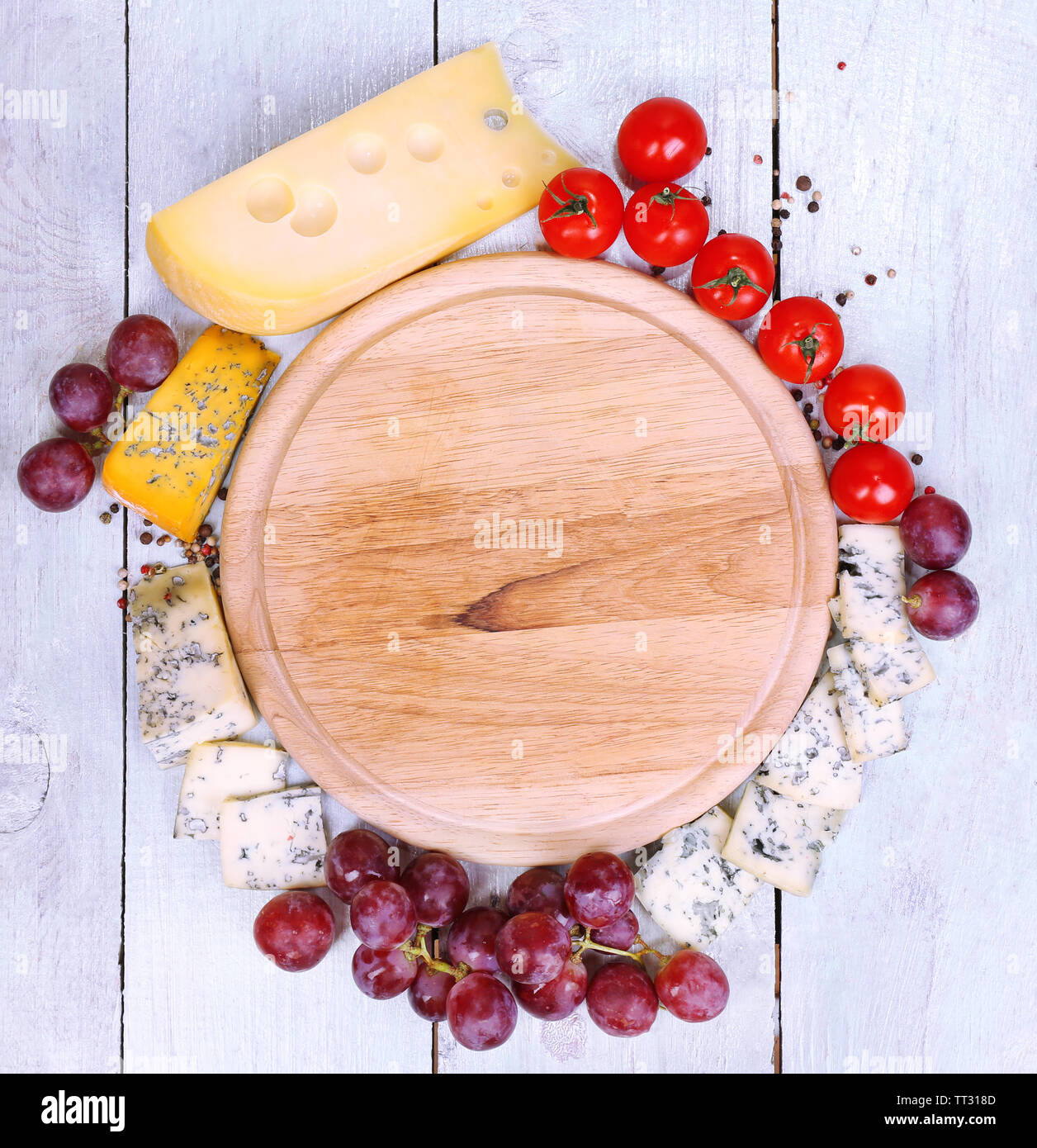 Different types of cheese with empty board on table close-up Stock ...