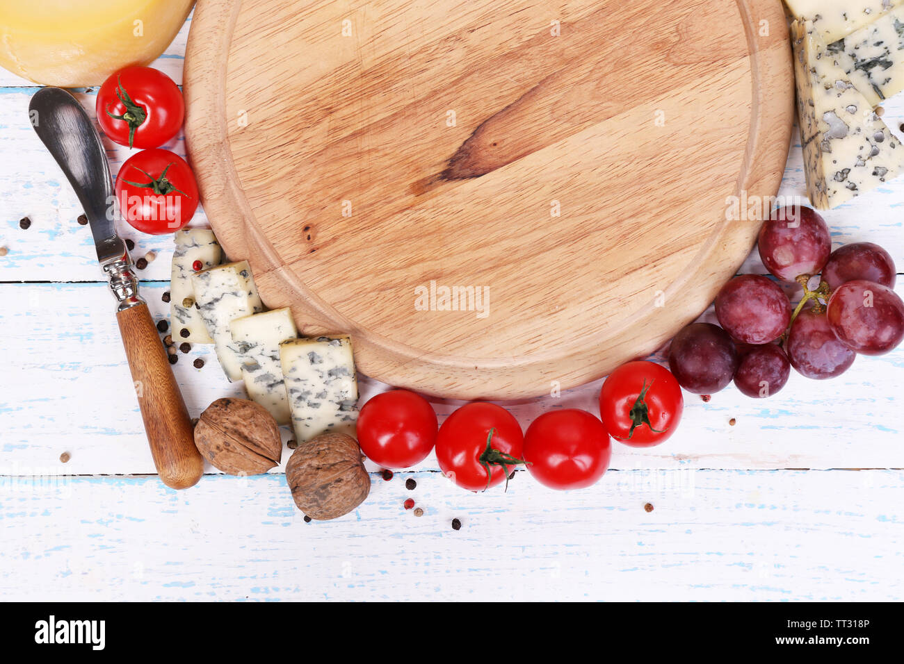 Different types of cheese with empty board on table close-up Stock ...