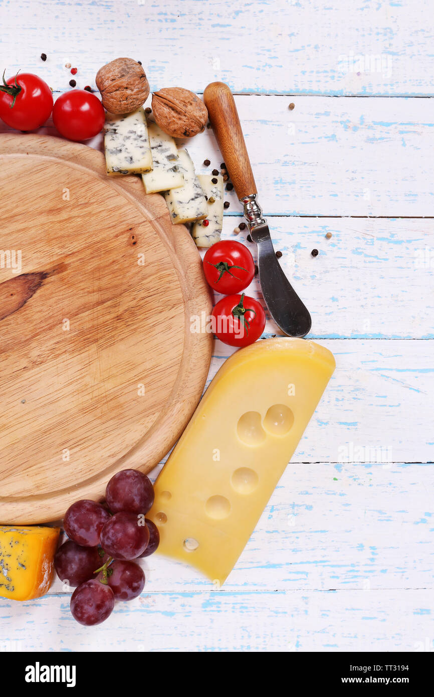 Different types of cheese with empty board on table close-up Stock ...