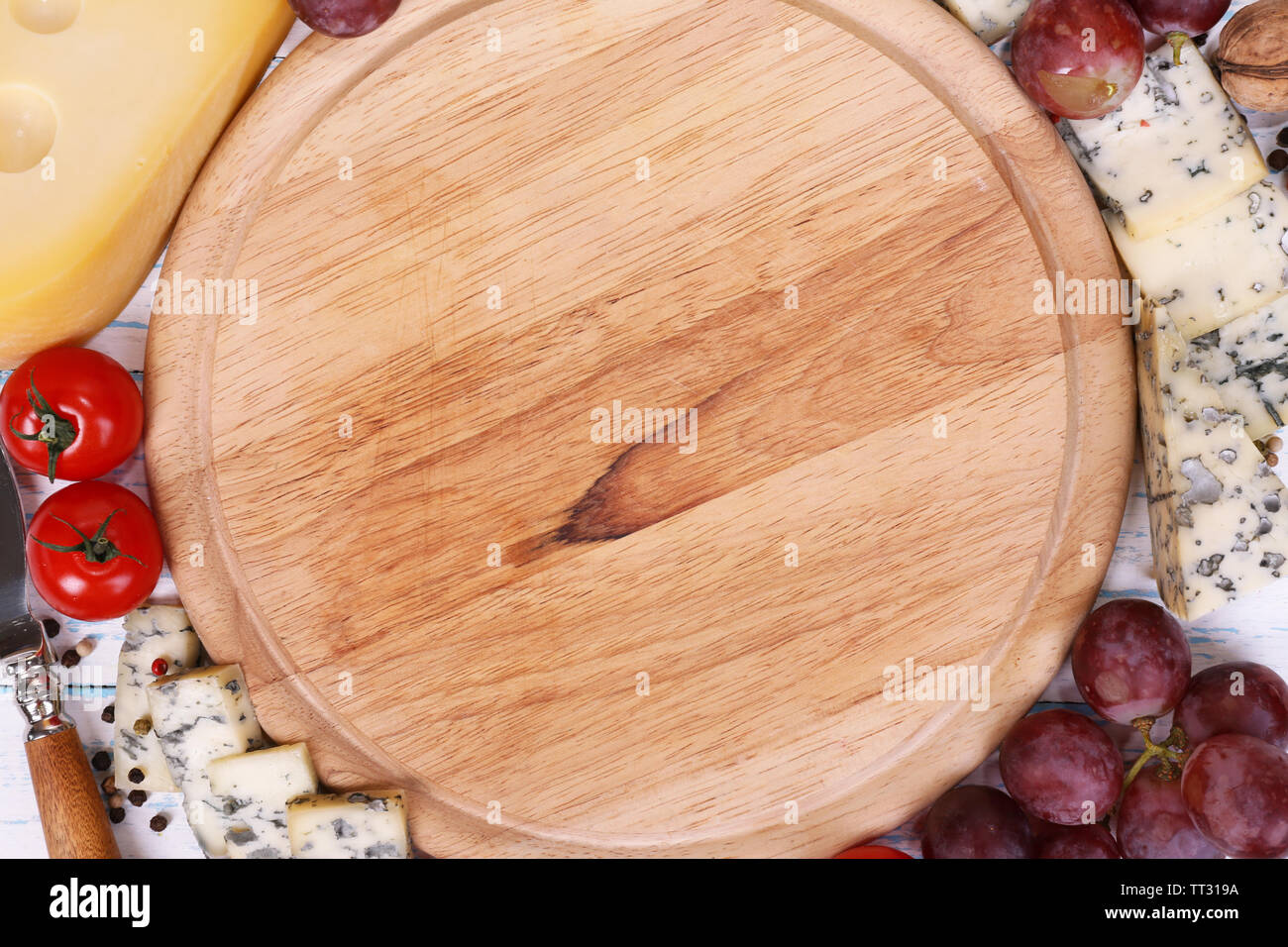 Different types of cheese with empty board on table close-up Stock ...