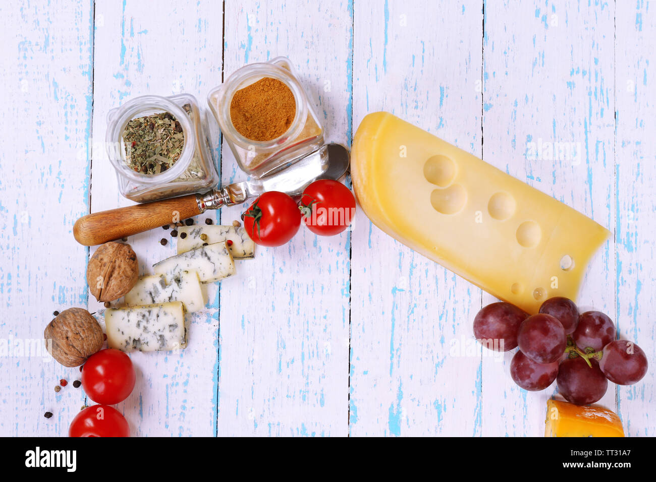 Different types of cheese with vegetables and spices on table close-up ...