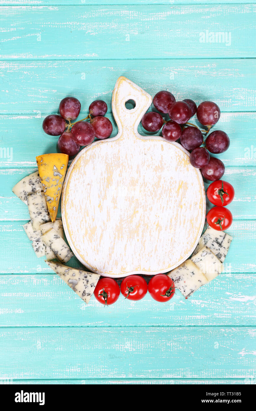 Different types of cheese with empty board on table close-up Stock ...