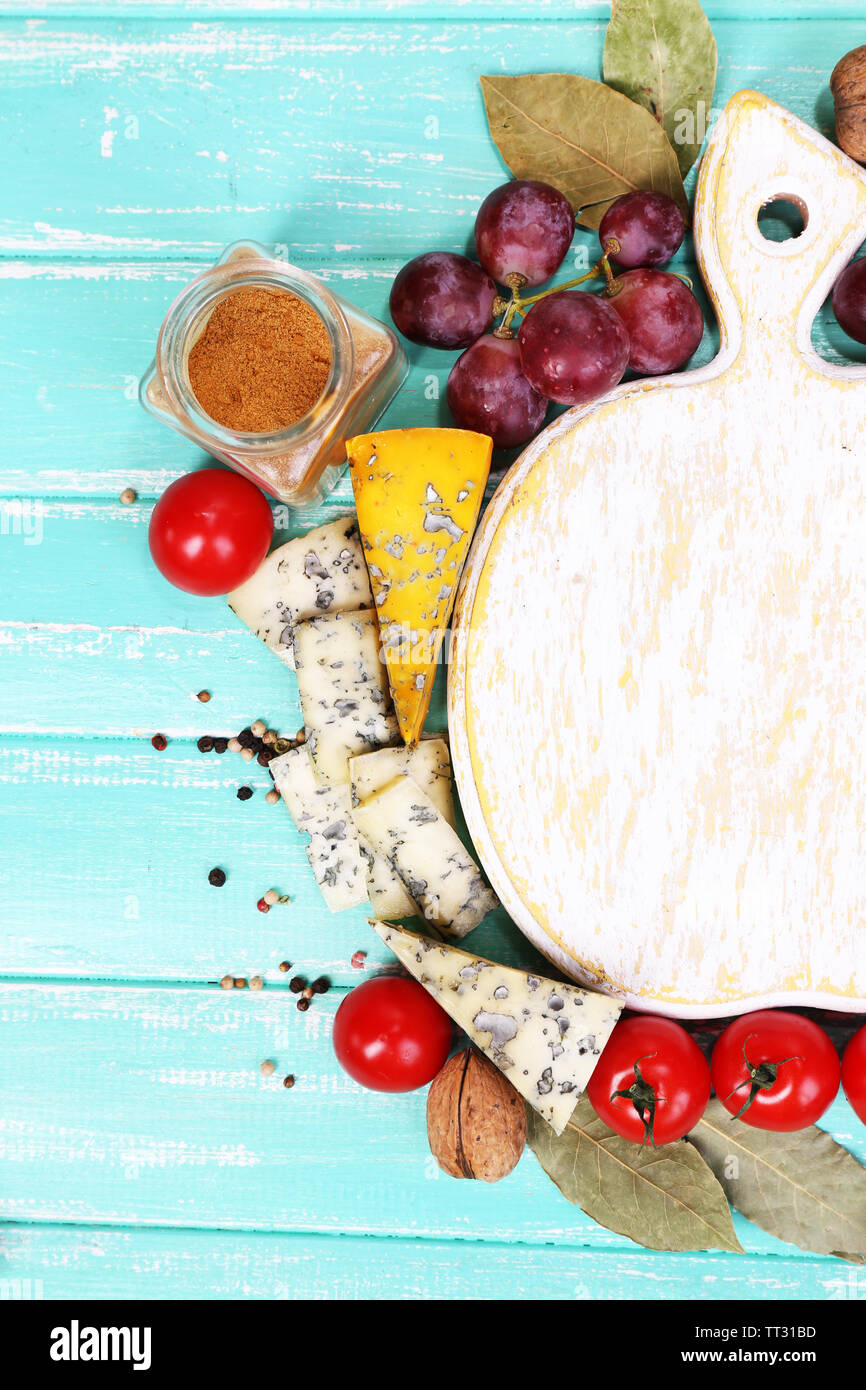 Different types of cheese with empty board on table close-up Stock ...