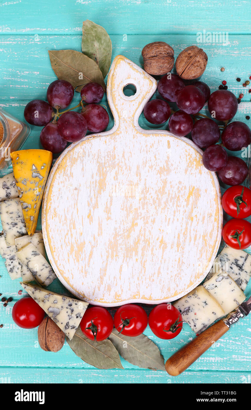 Different types of cheese with empty board on table close-up Stock ...