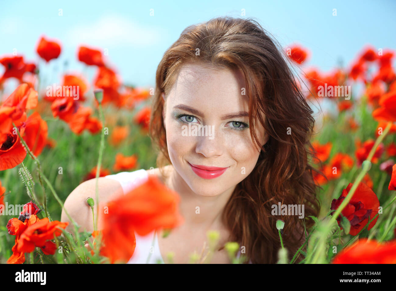 Beautiful young woman in poppy field Stock Photo - Alamy