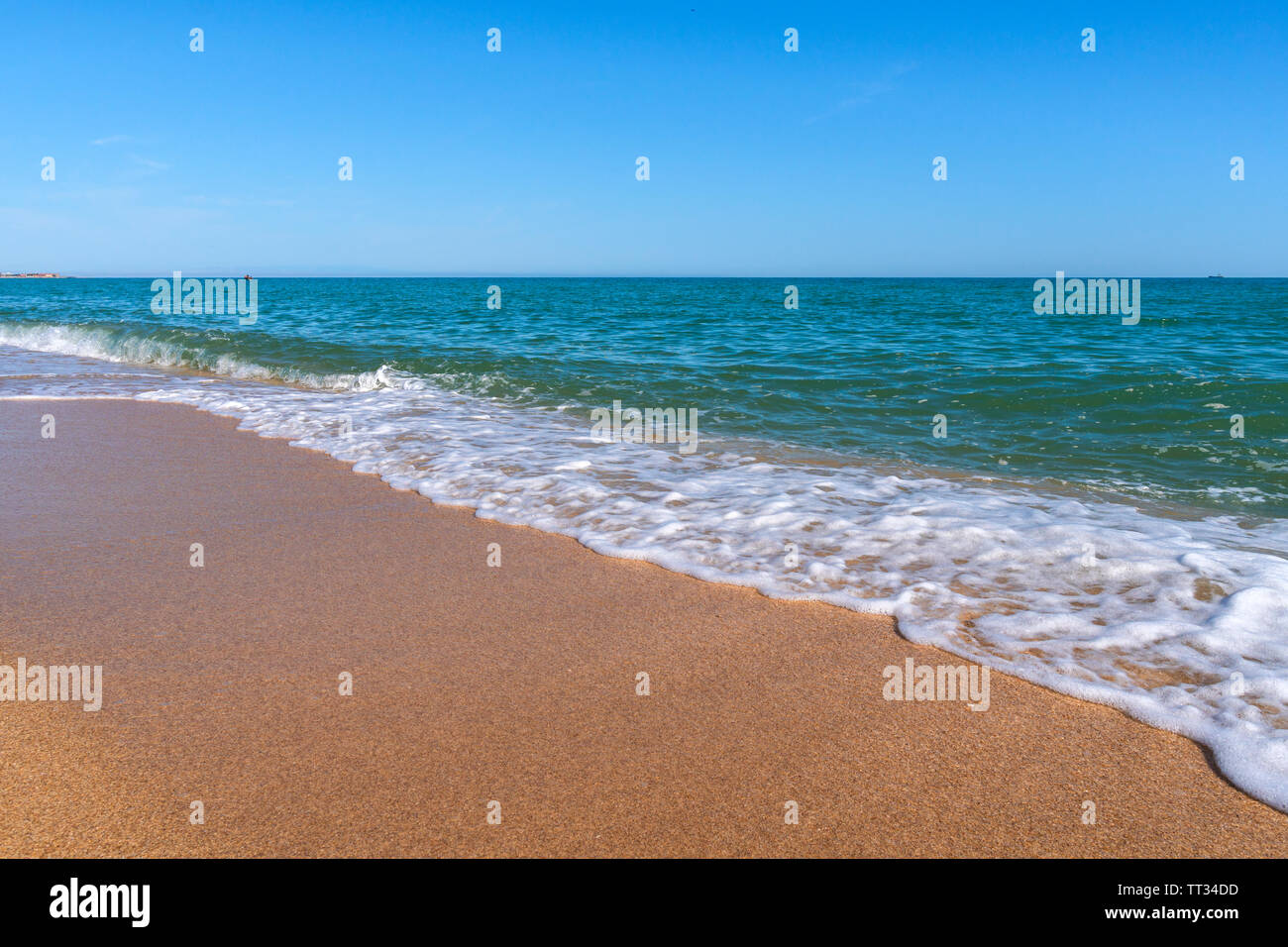 Empty summer beach with golden sand and azure water Stock Photo - Alamy