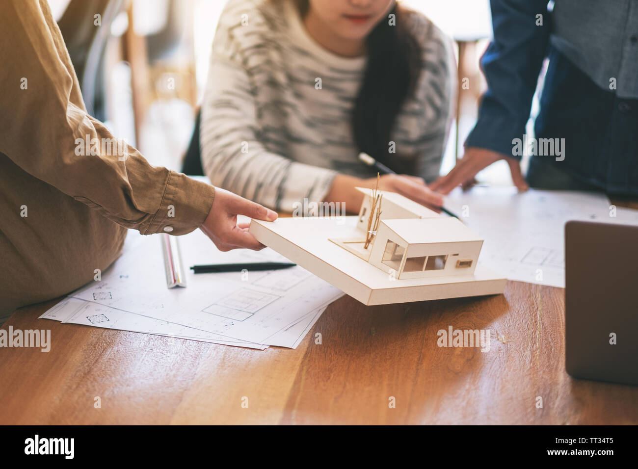 Group of an architect holding and discussing about an architecture ...