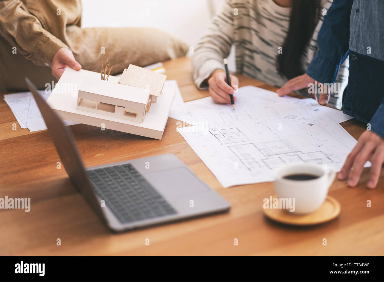 Group of an architect holding and discussing about an architecture ...