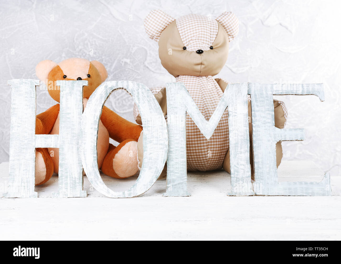 Decorative letters forming word HOME with teddy bear on grey background ...