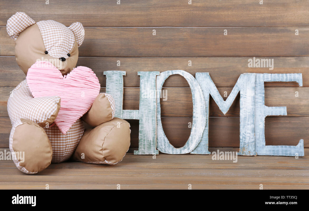 Decorative letters forming word HOME with teddy bear on wooden ...