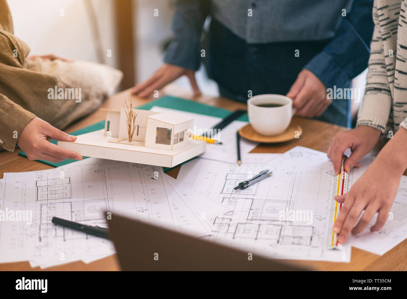 Group of an architect working and measuring scale of a mass model on ...