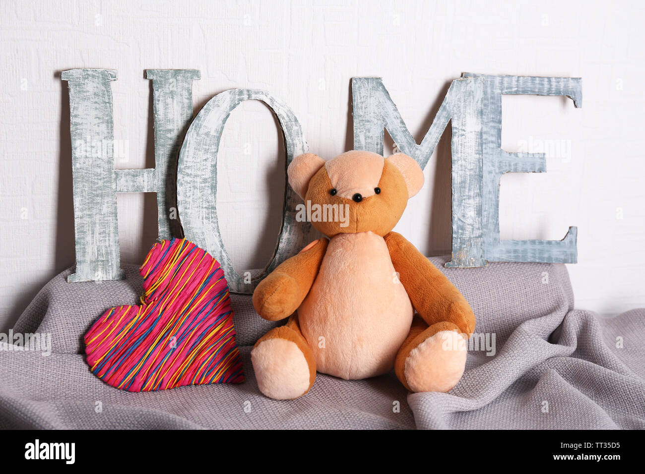 Decorative letters forming word HOME with teddy bear on wall background ...