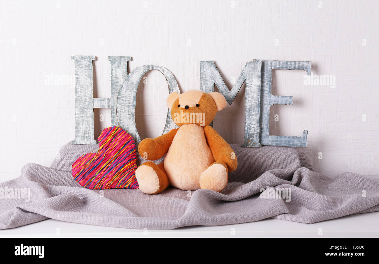 Decorative letters forming word HOME with teddy bear on wall background ...