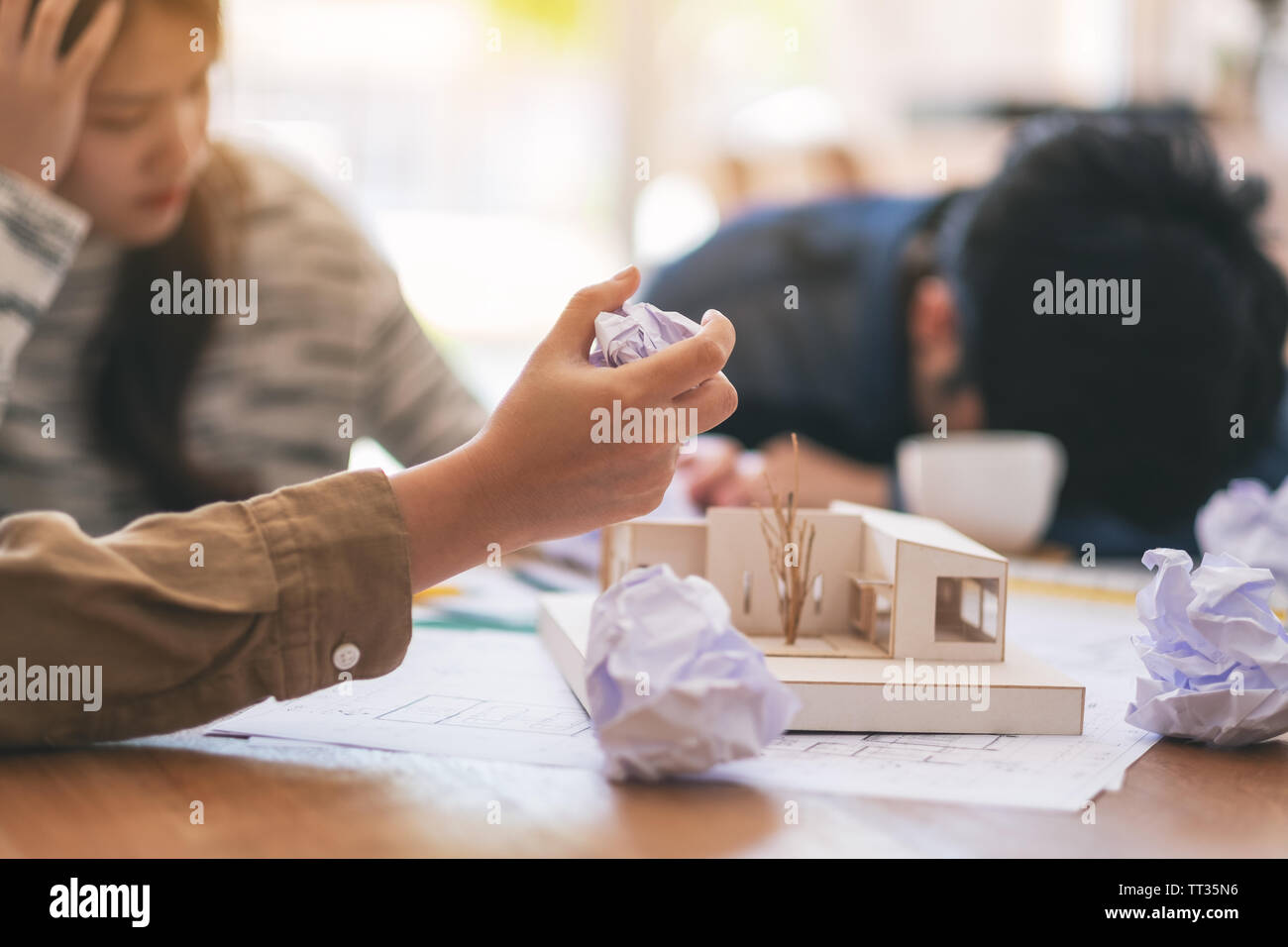 An architect screwed up papers by hand when feel stressed after working ...