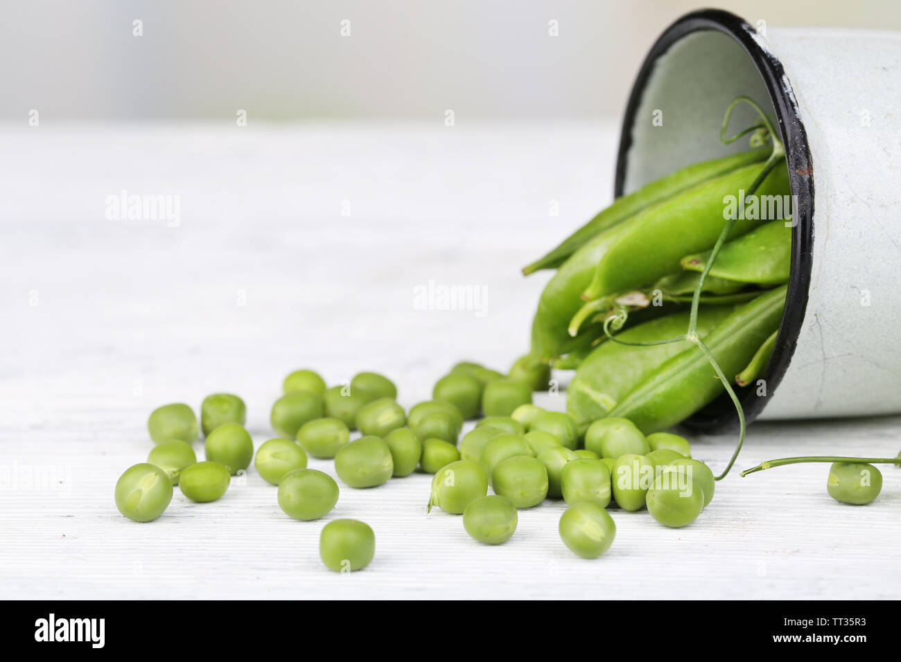 Fresh green peas in metal cup on wooden table Stock Photo - Alamy