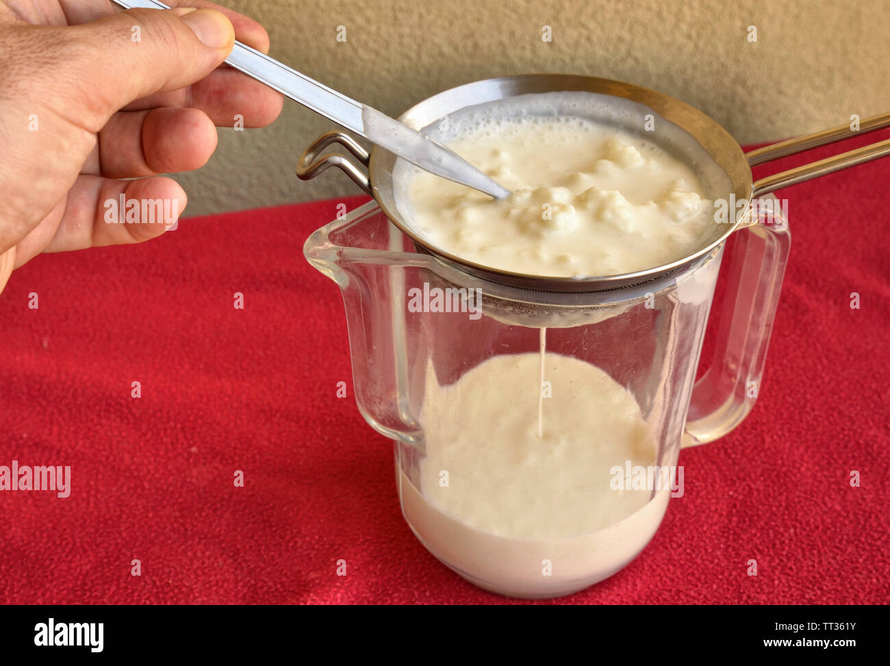 Pouring of the Kefir, the hand of a Caucasian man gently moves the ...