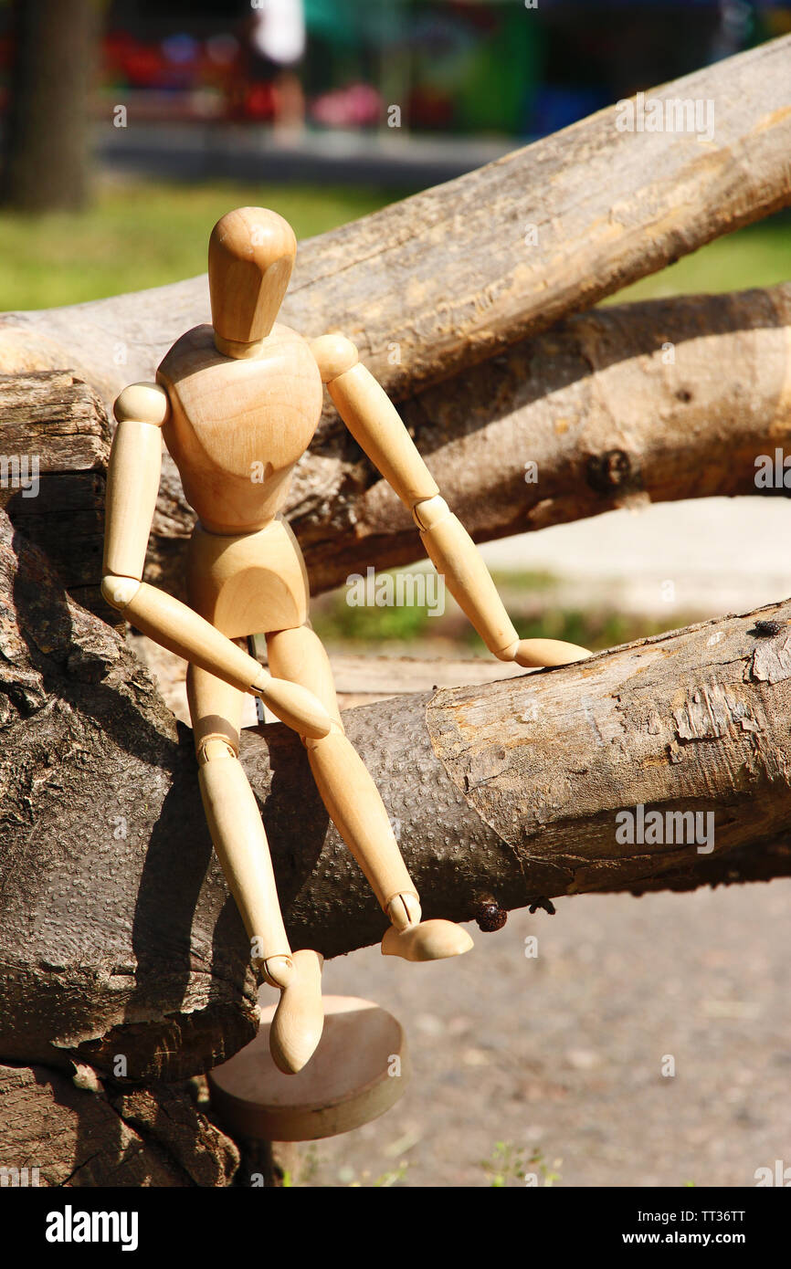 Wooden pose puppet sitting on wooden timber, outdoors Stock Photo - Alamy