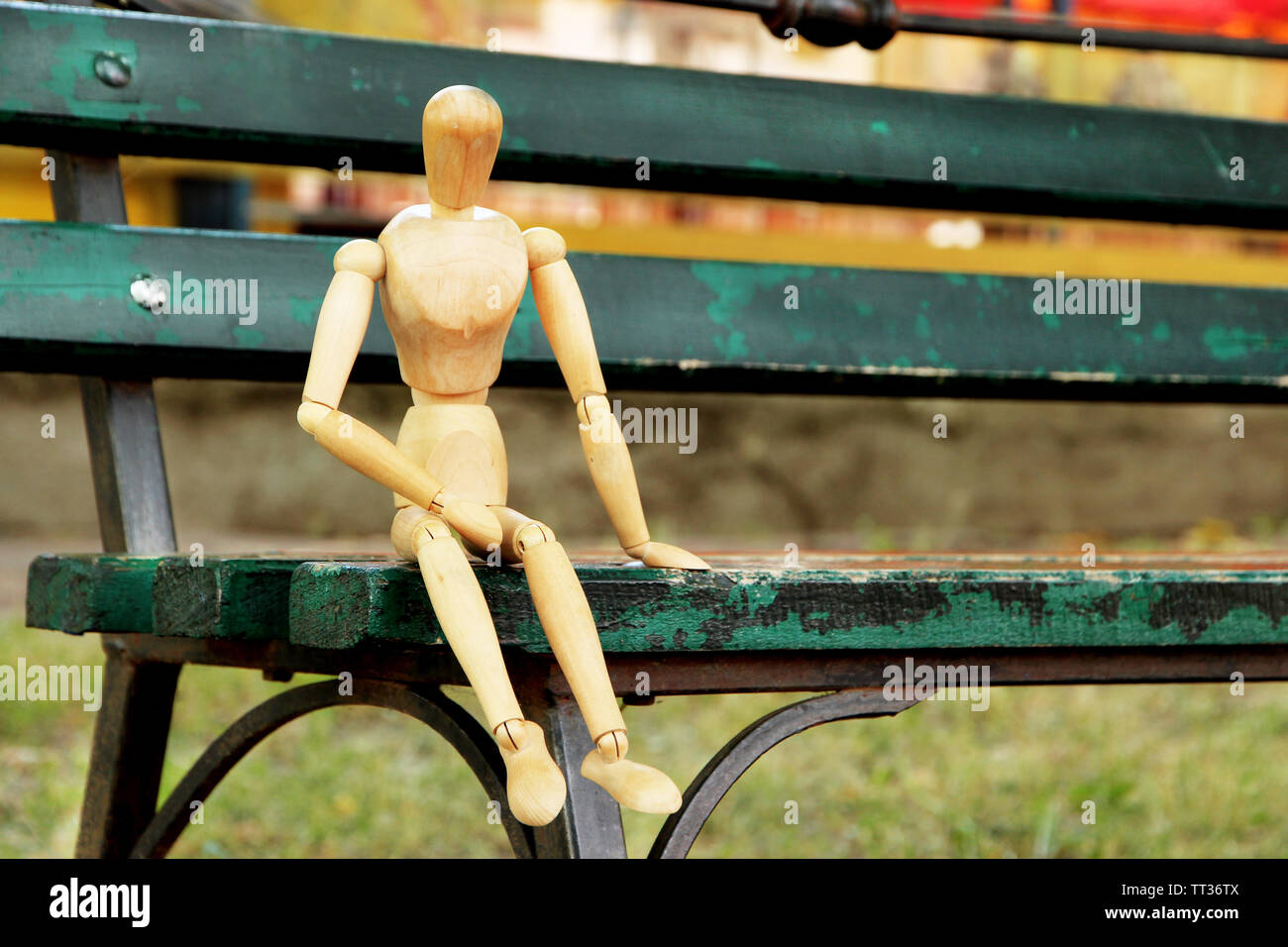 Wooden pose puppet sitting on bench outdoors Stock Photo - Alamy