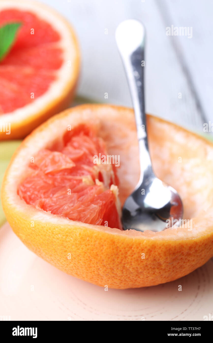 Ripe grapefruits on plate, on color wooden background Stock Photo - Alamy