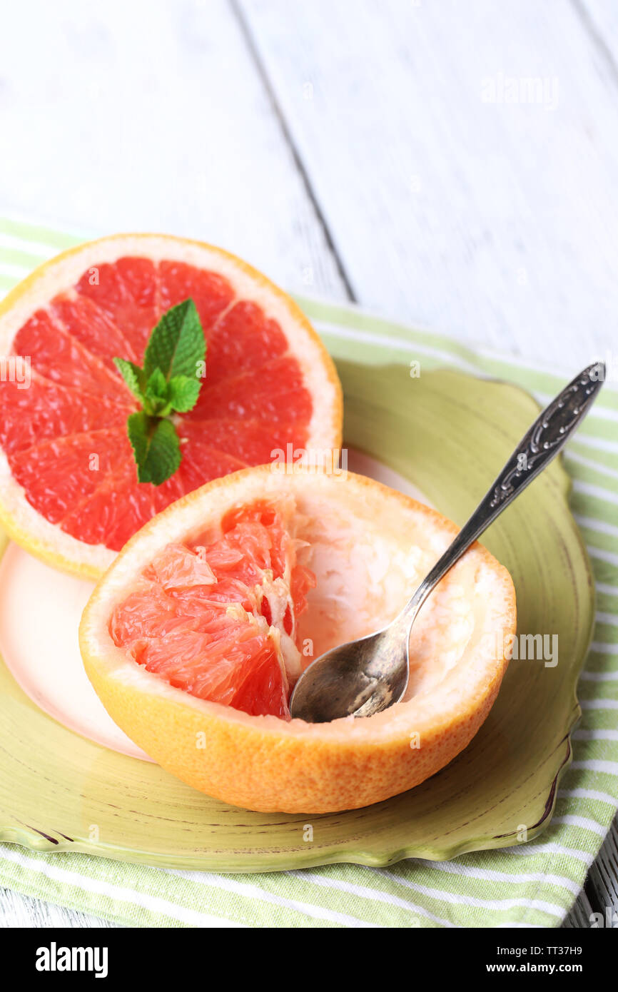 Ripe grapefruits on plate, on color wooden background Stock Photo - Alamy