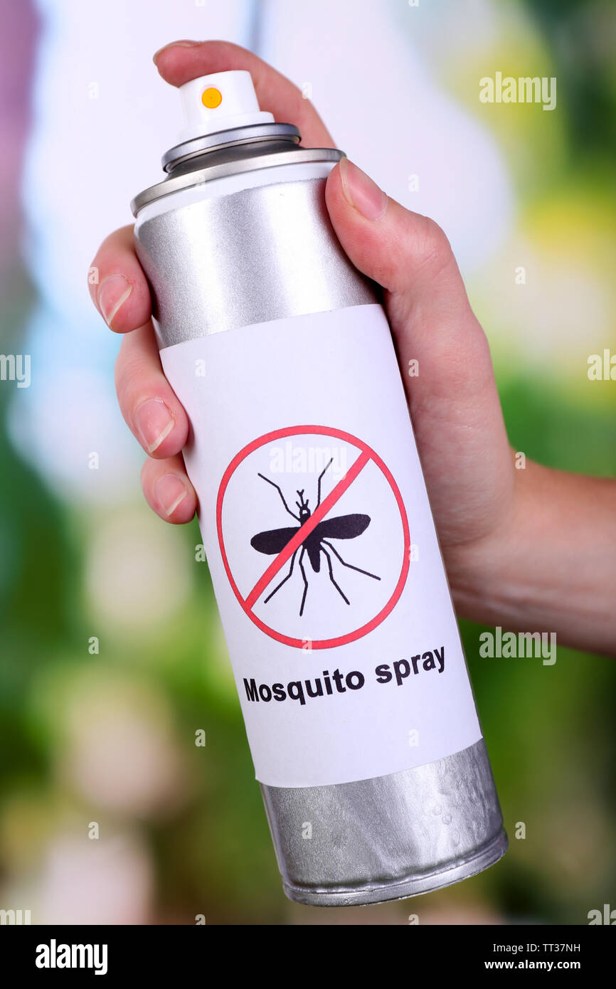 Hand holding mosquito spray on nature background Stock Photo - Alamy