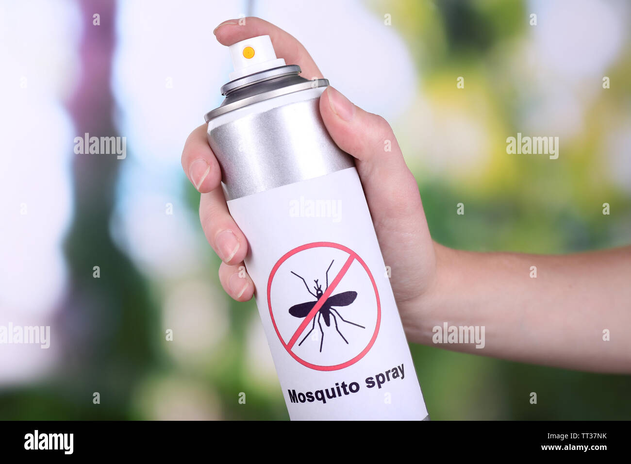 Hand holding mosquito spray on nature background Stock Photo - Alamy