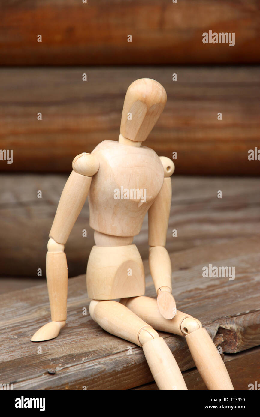 Wooden pose puppet sitting on wooden bench, outdoors Stock Photo - Alamy