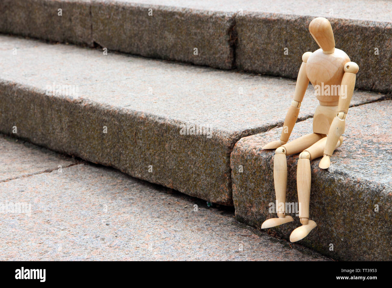 Wooden pose puppet sitting on stair, outdoors Stock Photo - Alamy