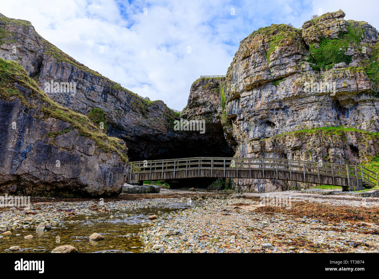 The entrance and the bridge over the stream at Smoo Cave. Smoo Cave is ...