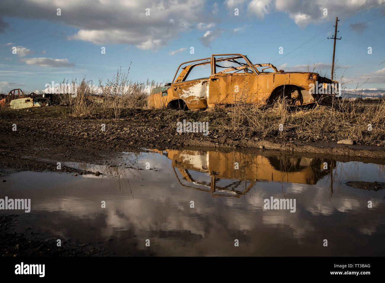 Old Lada chassis reflected on a puddle in the outskirts of Gyumri ...