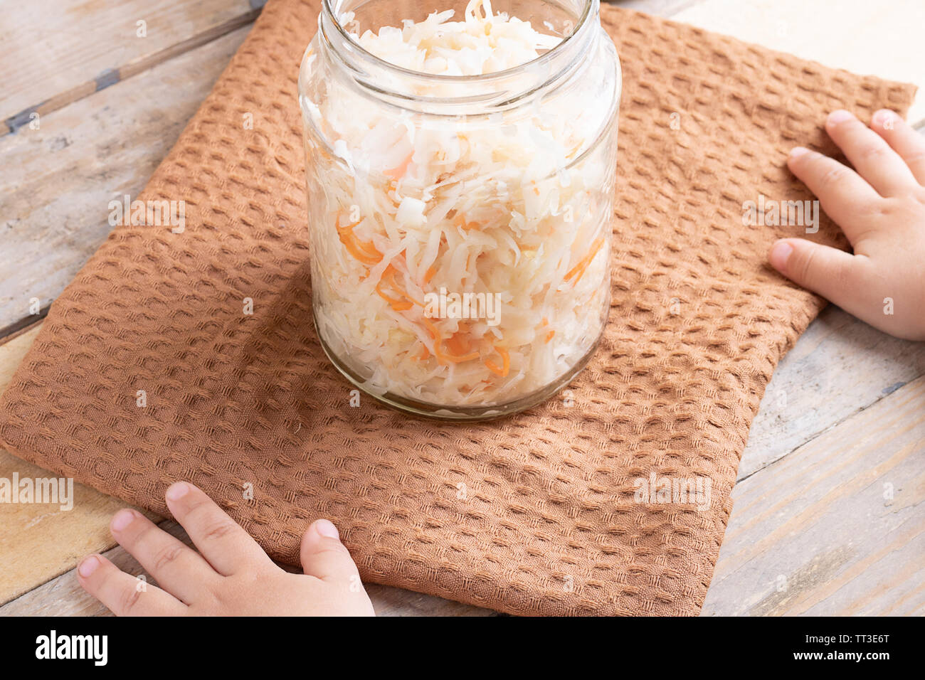 fermented cabbage in jar, wooden background and copy space, canned meal ...