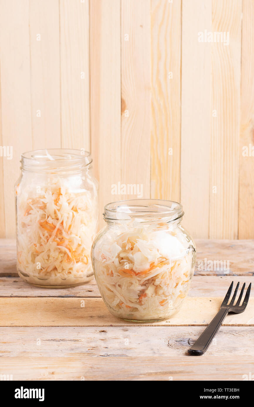 fermented cabbage in jar, wooden background and copy space, canned meal ...