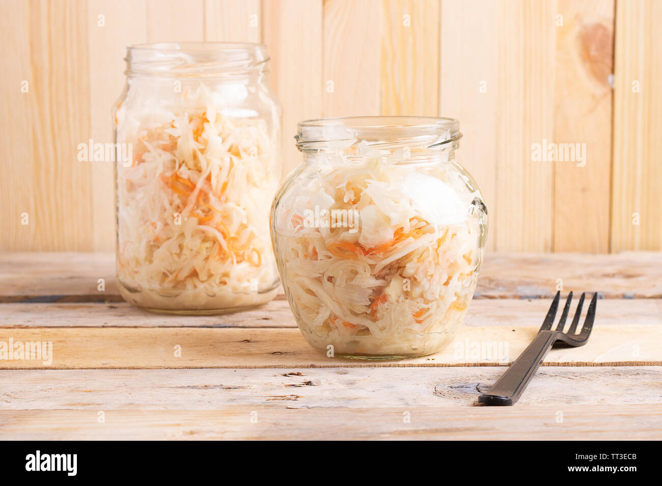 fermented cabbage in jar, wooden background and copy space, canned meal ...