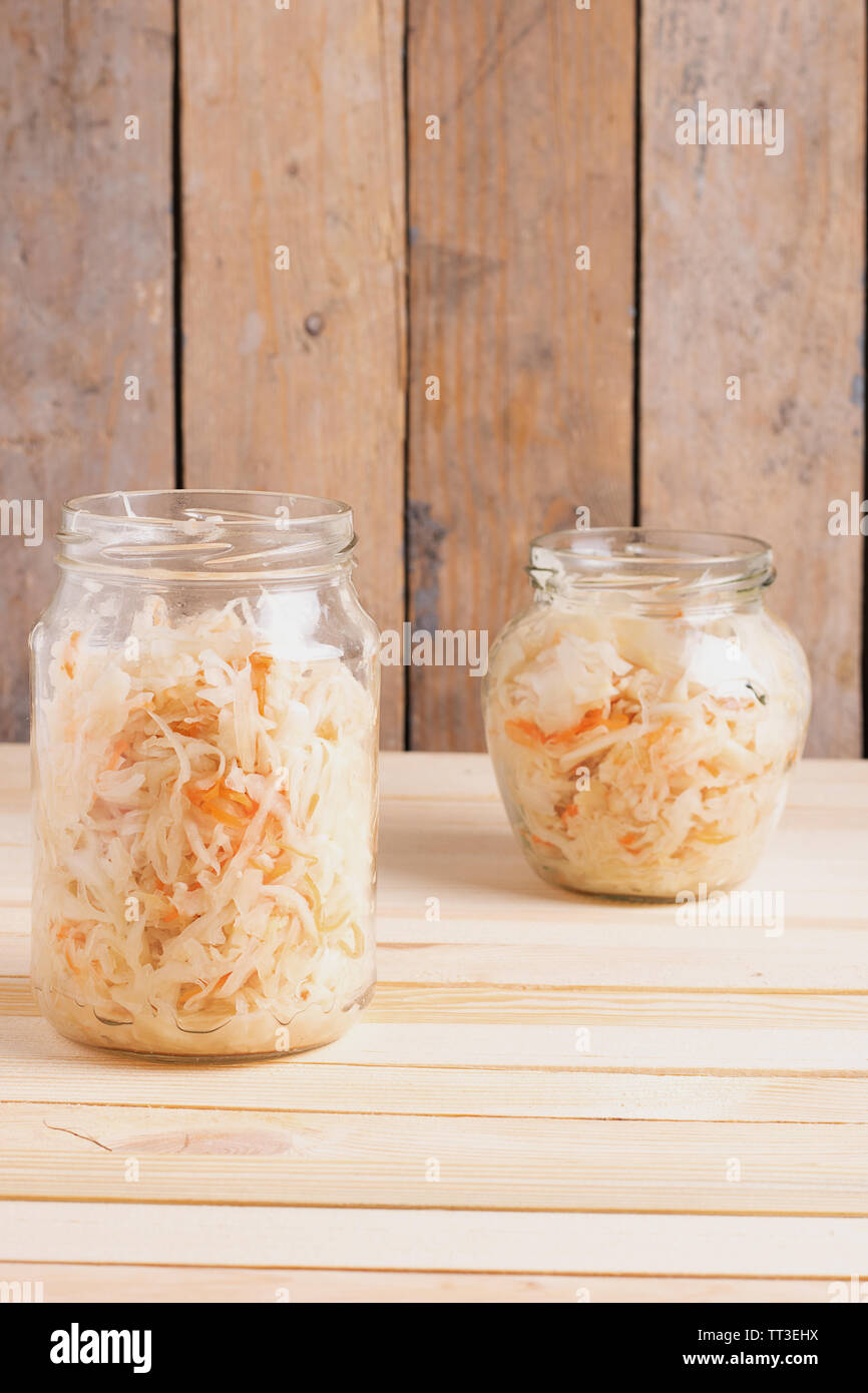 fermented cabbage in jar, wooden background and copy space, canned meal ...