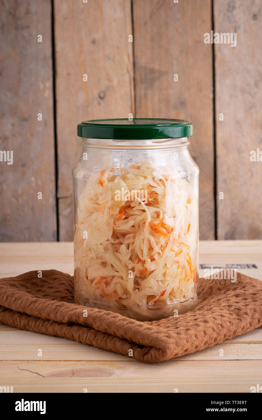 fermented cabbage in jar, wooden background and copy space, canned meal ...