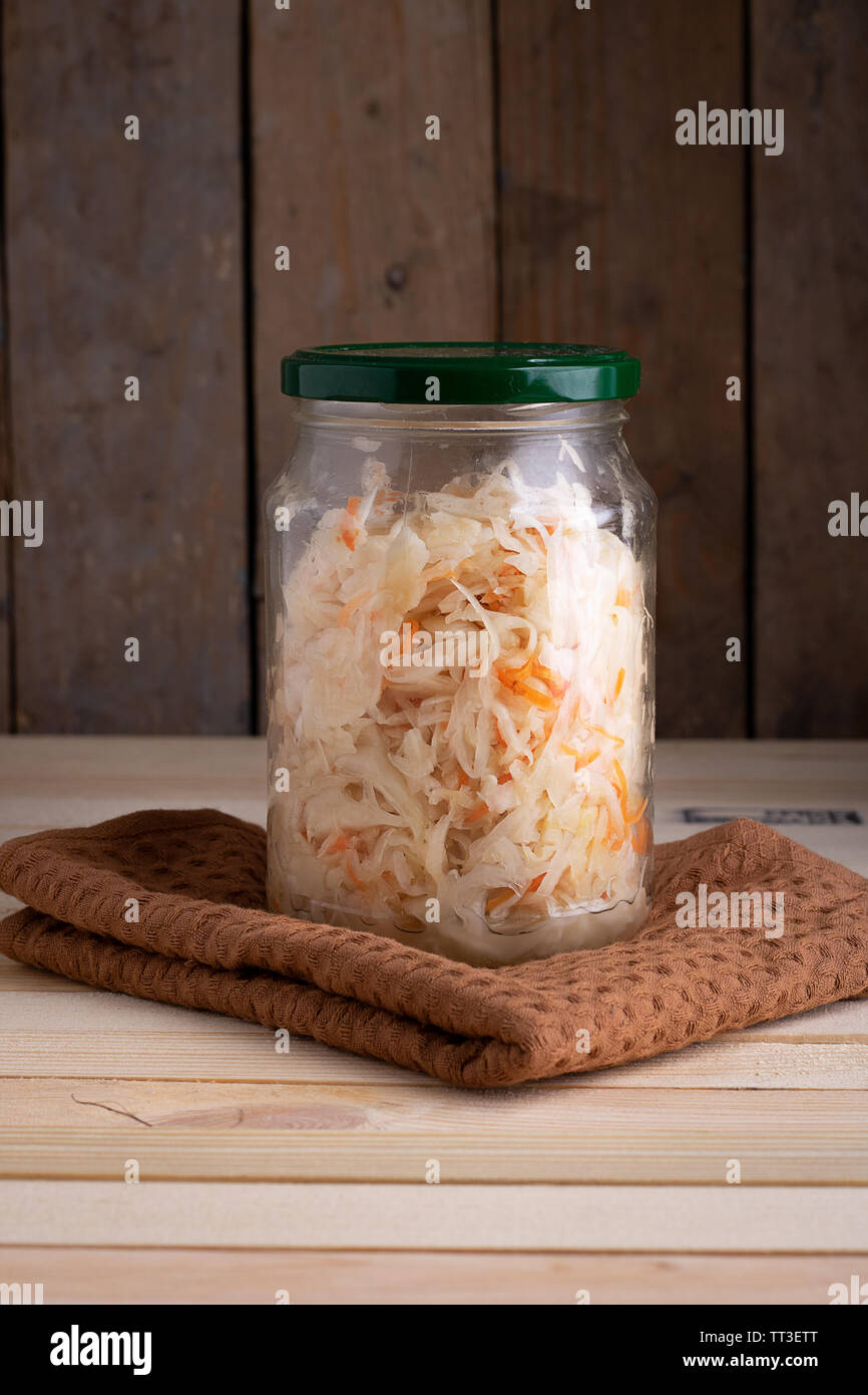 fermented cabbage in jar, wooden background and copy space, canned meal ...