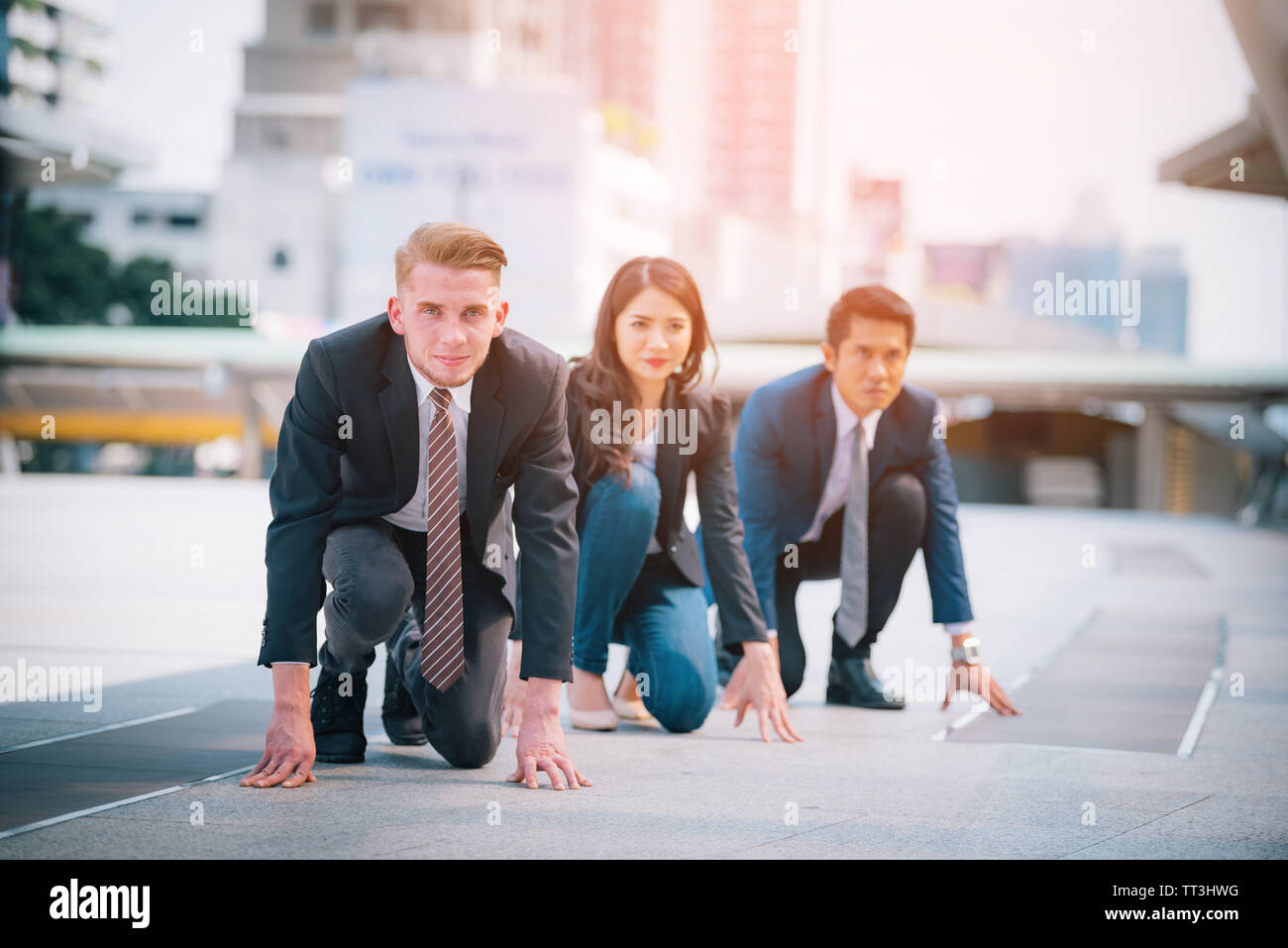 Business team ready to run at start point on blurred city background ...