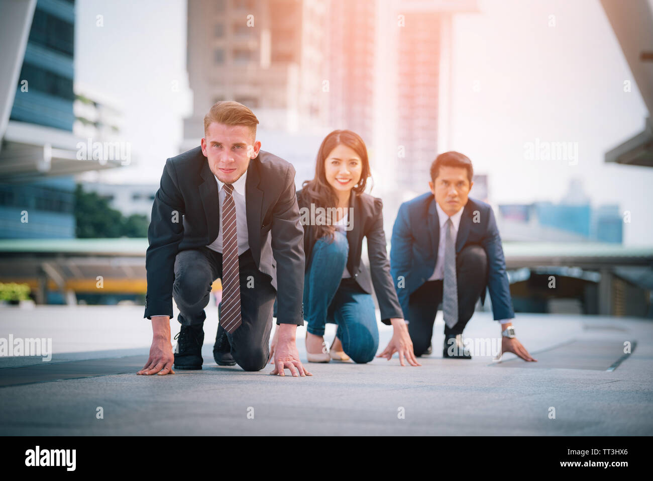 Business team ready to run at start point on blurred city background ...