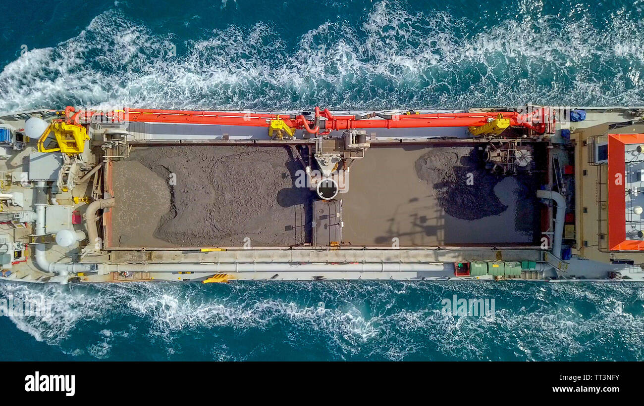 Red Trailing Suction Hopper-Dredger ship roaring across the sea, Aerial ...