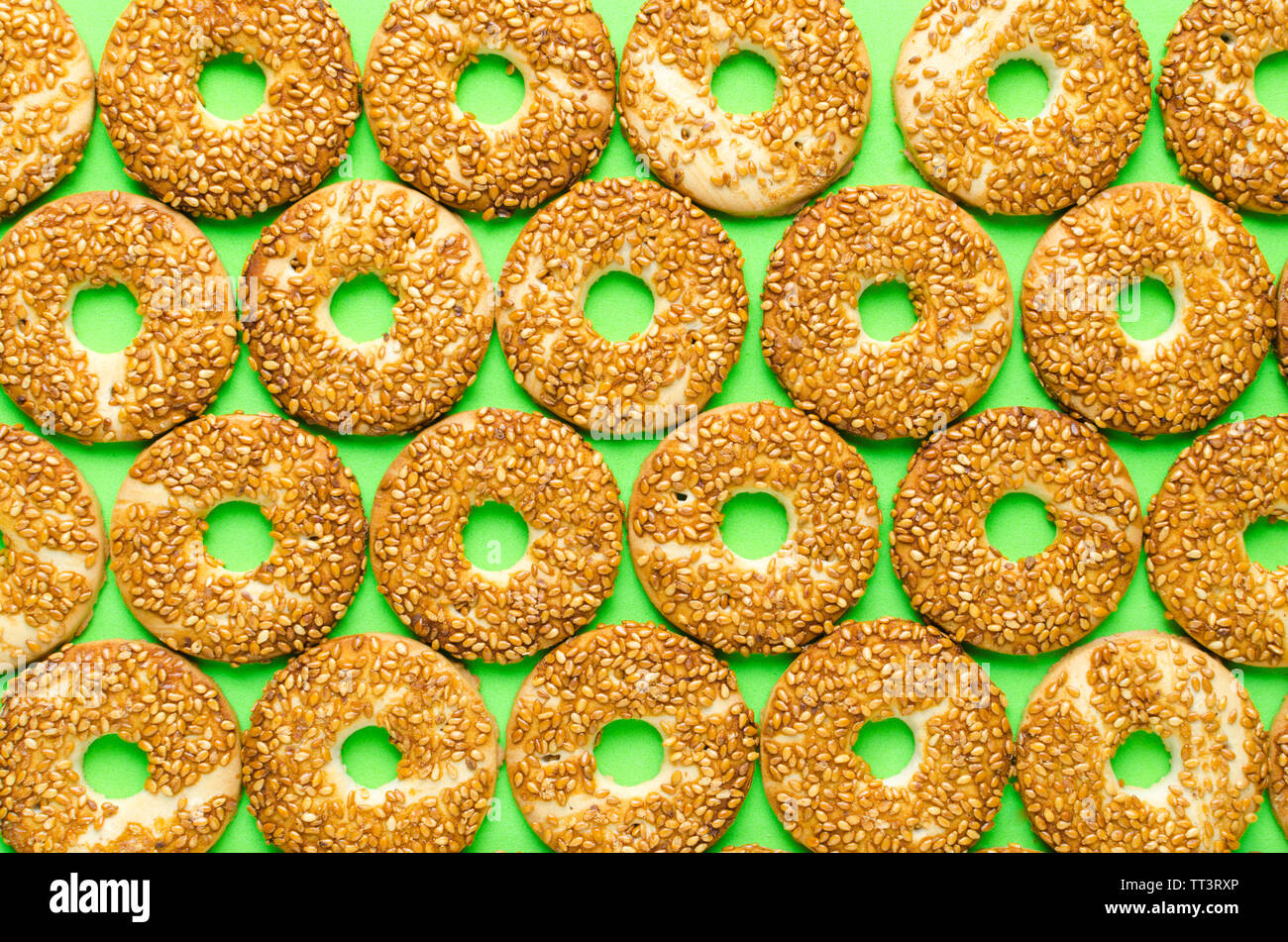 Round cookies with sesame seeds on a bright green background ...
