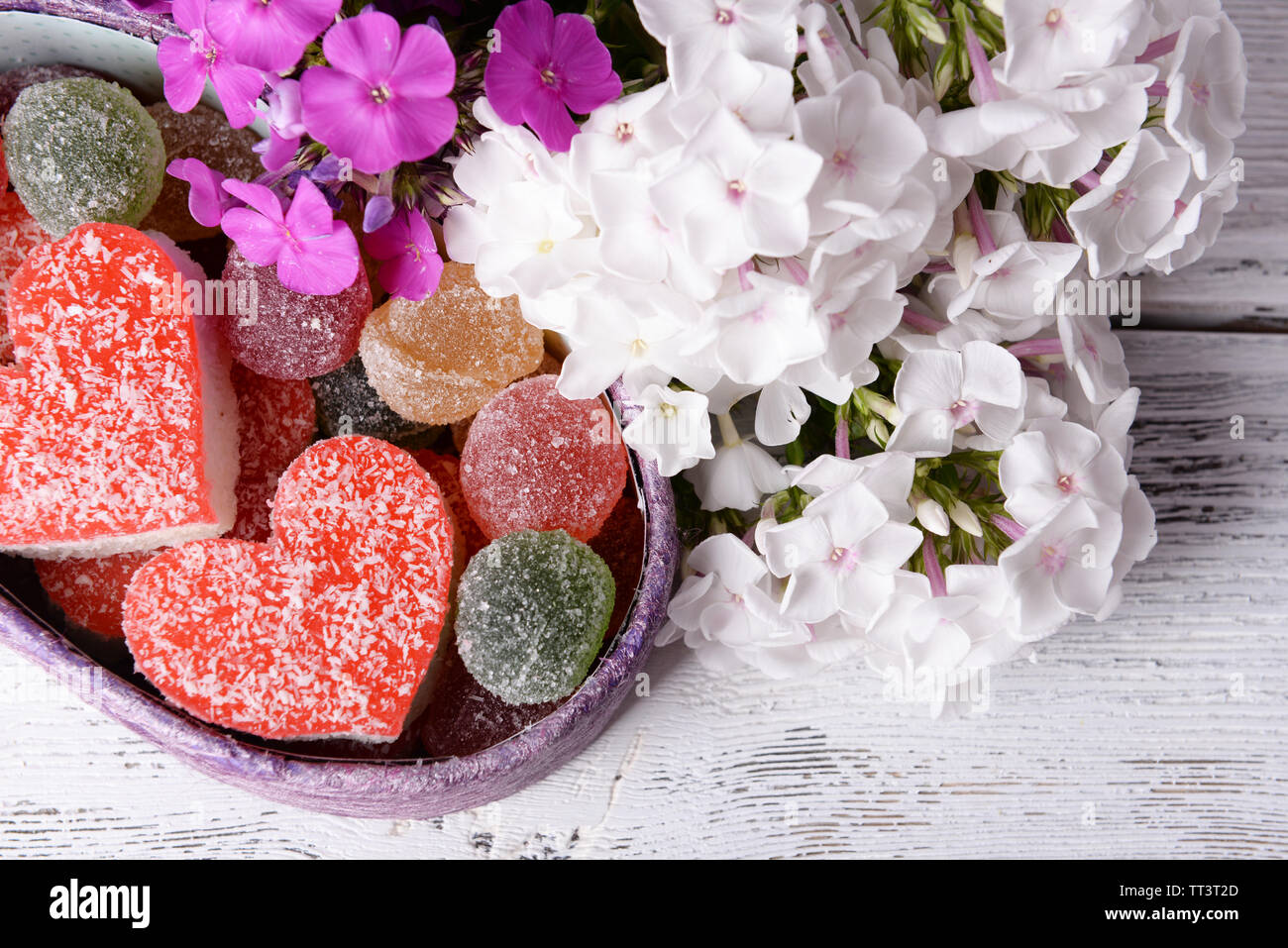 Present box with sweets and flowers on wooden background Stock Photo ...