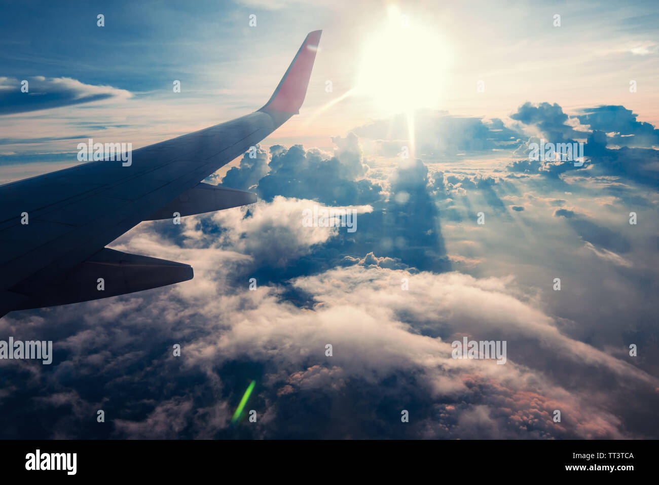 The wing of airplane and sunset on blue sky and beautiful clouds.Light ...