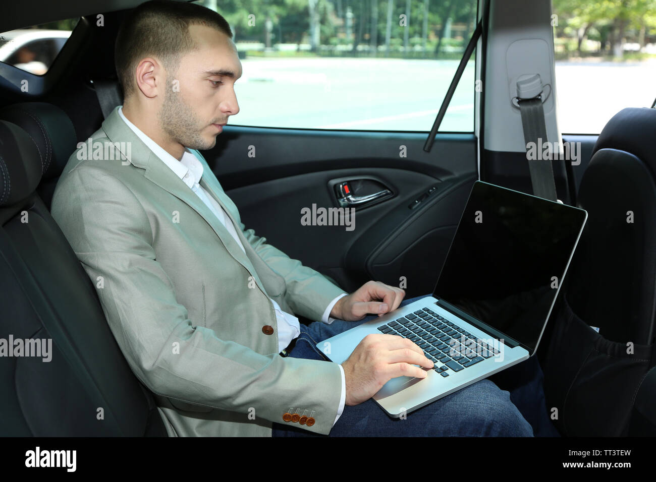 Man sitting in car with laptop Stock Photo - Alamy