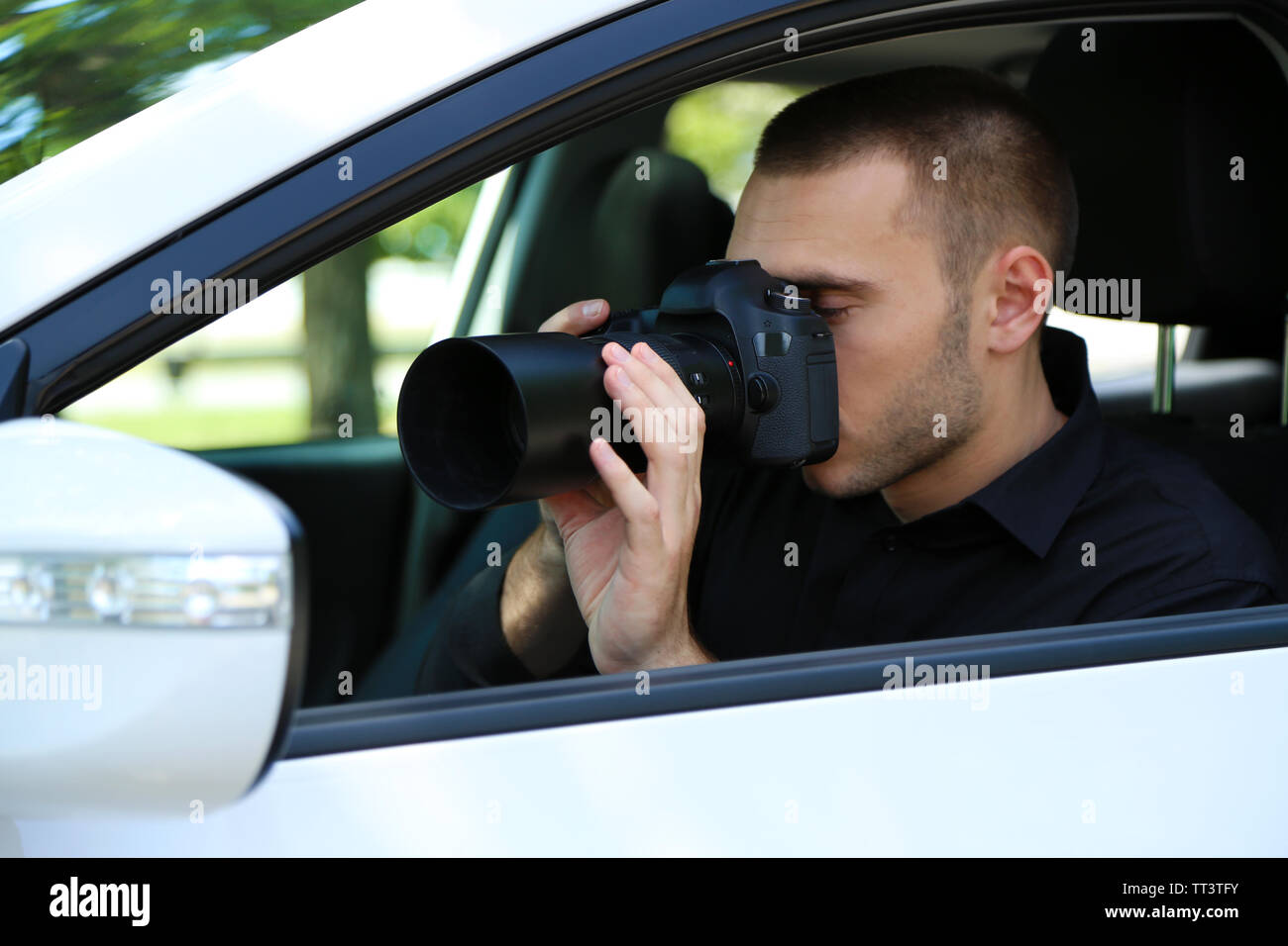 Man in car with photo camera Stock Photo - Alamy