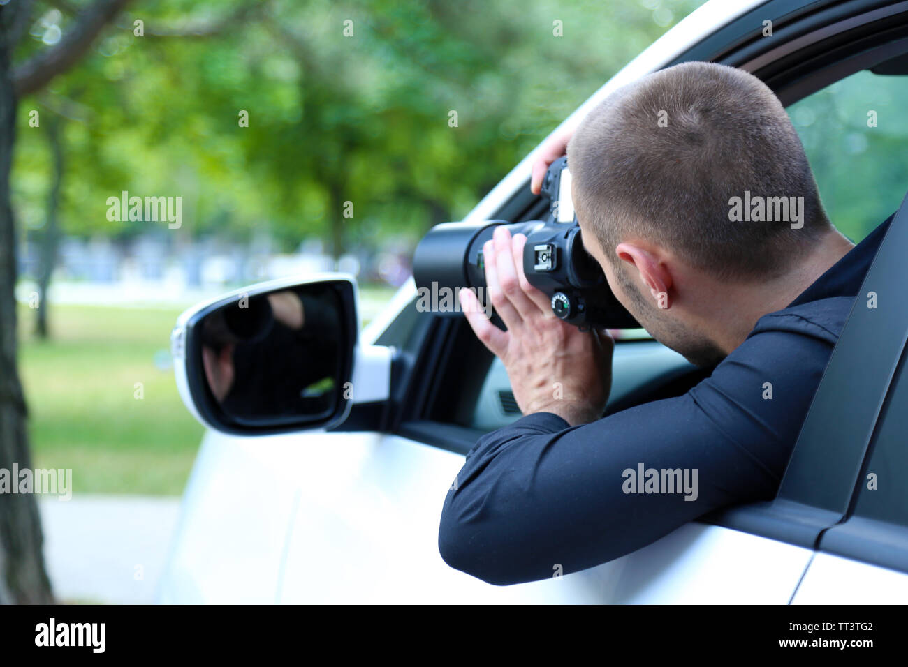 Man in car with photo camera Stock Photo - Alamy