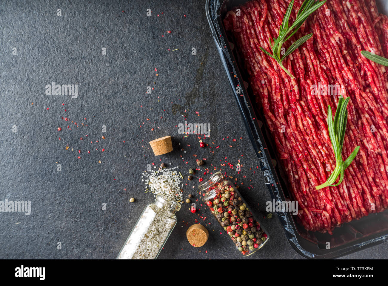 Raw minced beef meat with herbs and spices for cooking, black concrete ...