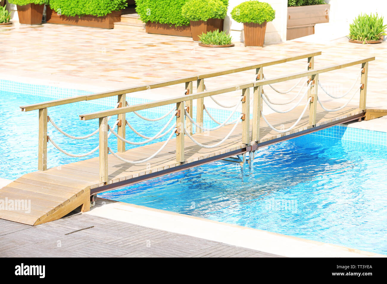Bridge across hotel swimming pool Stock Photo - Alamy