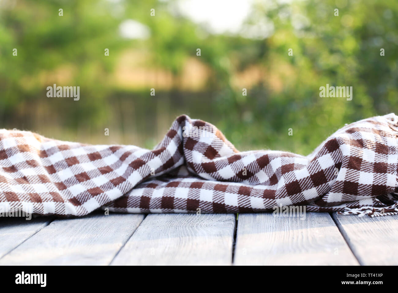 Wooden table with cloth on bright background Stock Photo - Alamy