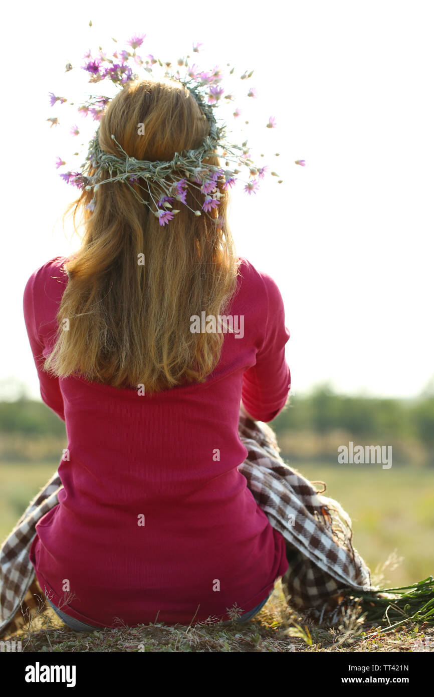 Beautiful girl sitting on haystack in field Stock Photo - Alamy